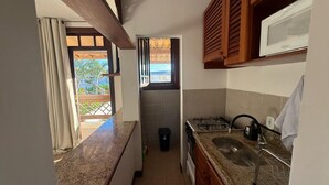 Uma cozinha compacta com fogão a gás, pia e armários de madeira.