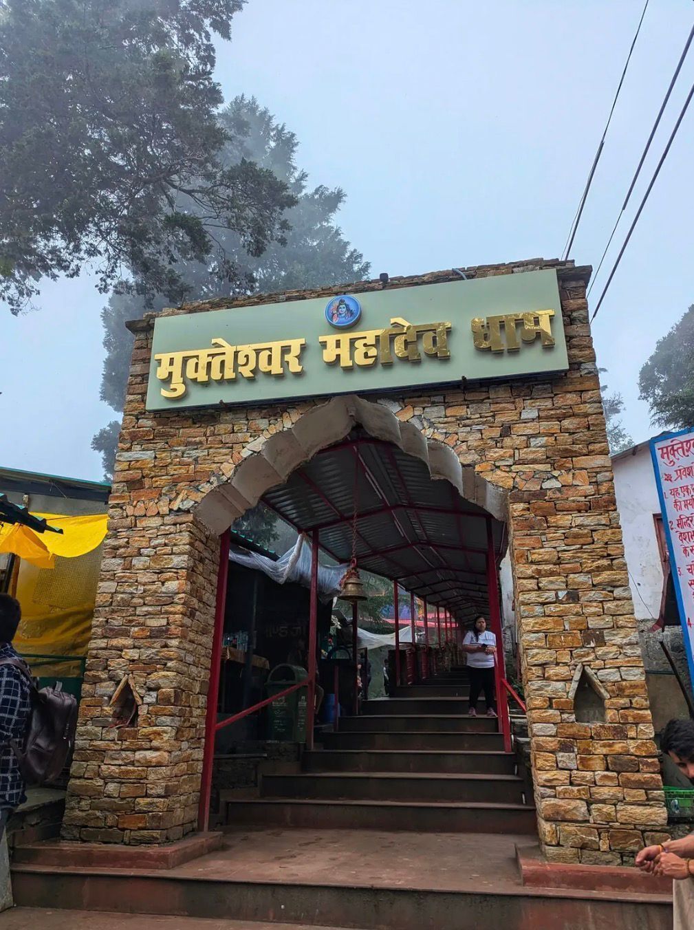 Entrada de um templo com um arco de pedra e degraus que levam até ele.