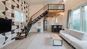 Um apartamento moderno com escada, cozinha, sala de jantar e sala de estar.