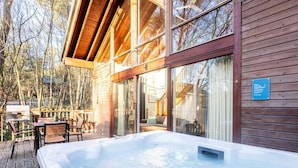 A wooden cabin with a hot tub and outdoor seating area.