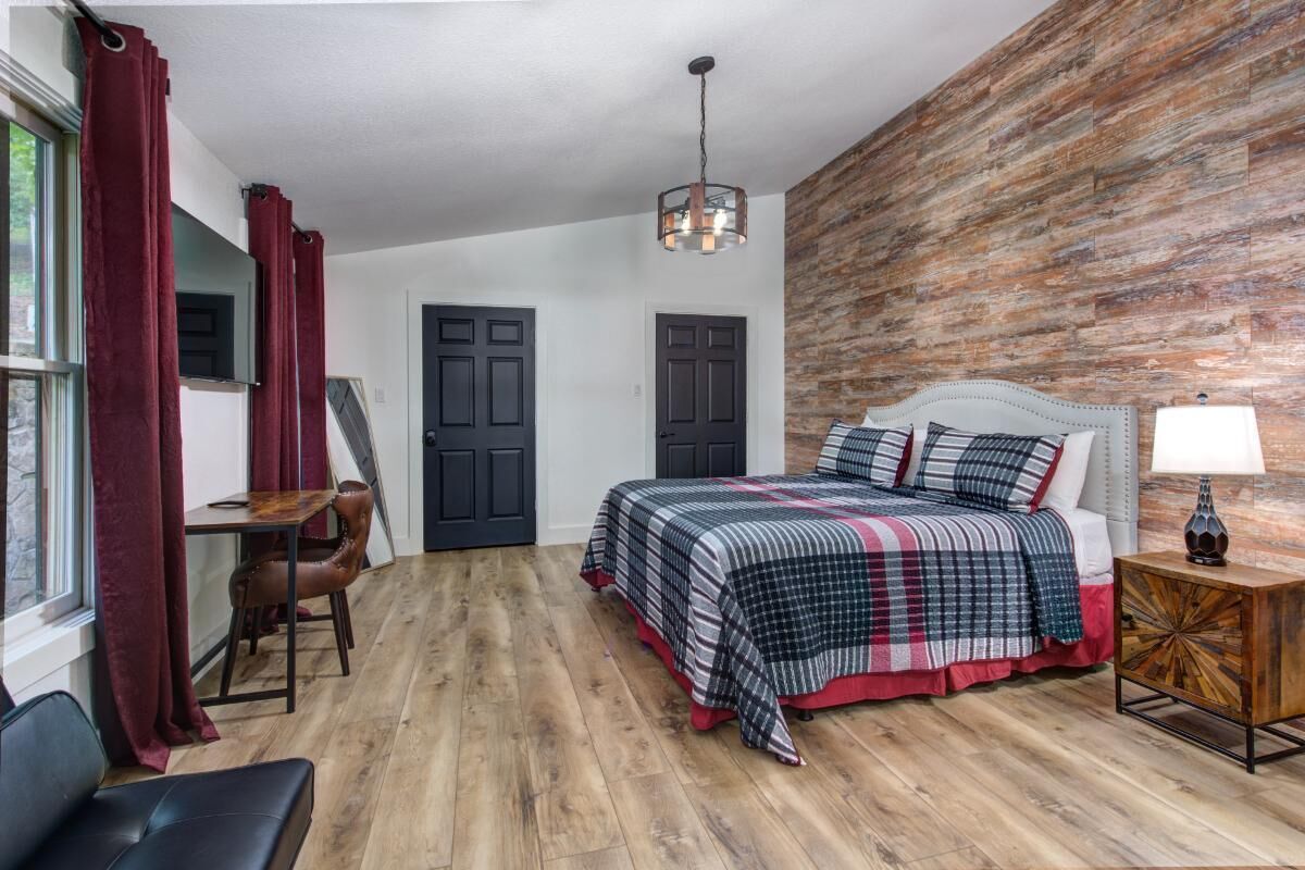 Quarto com cama, escrivaninha e cadeira.
