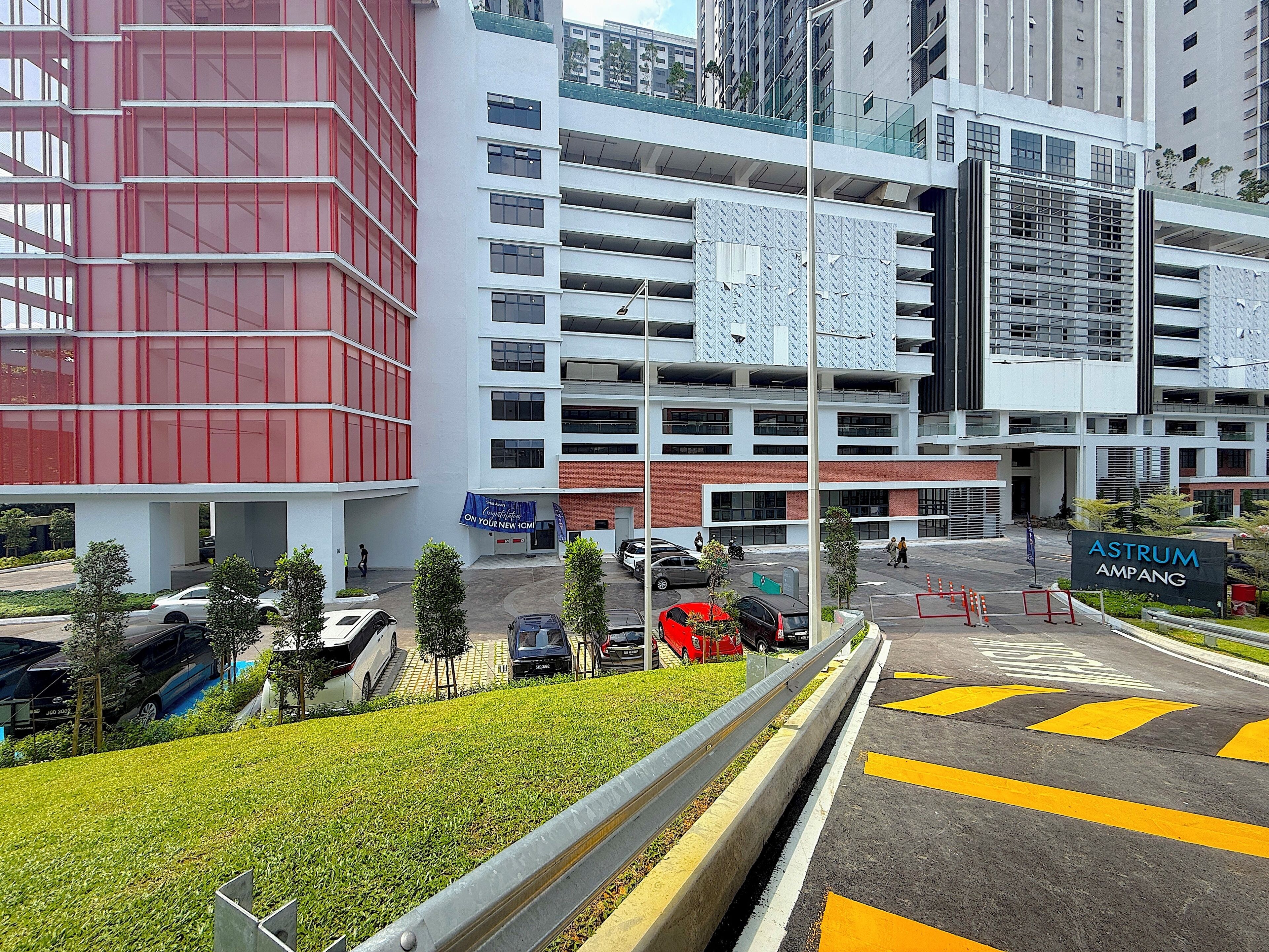 Uma estrutura de estacionamento em vários andares com uma placa indicando 'ASTRUM AMPANG'.