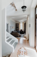 Um interior moderno com uma escada, um sofá, uma estante de livros e um padrão decorativo no chão.