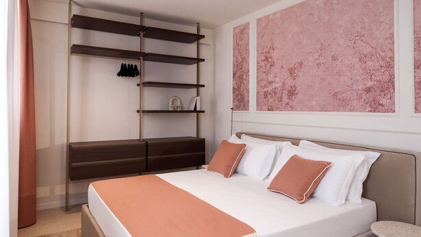 Quarto com cama, mesa de cabeceira, cômoda, estante e mesa redonda.