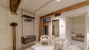 Casa de banho moderna com teto de madeira, espelho, porta-toalhas e um banco.