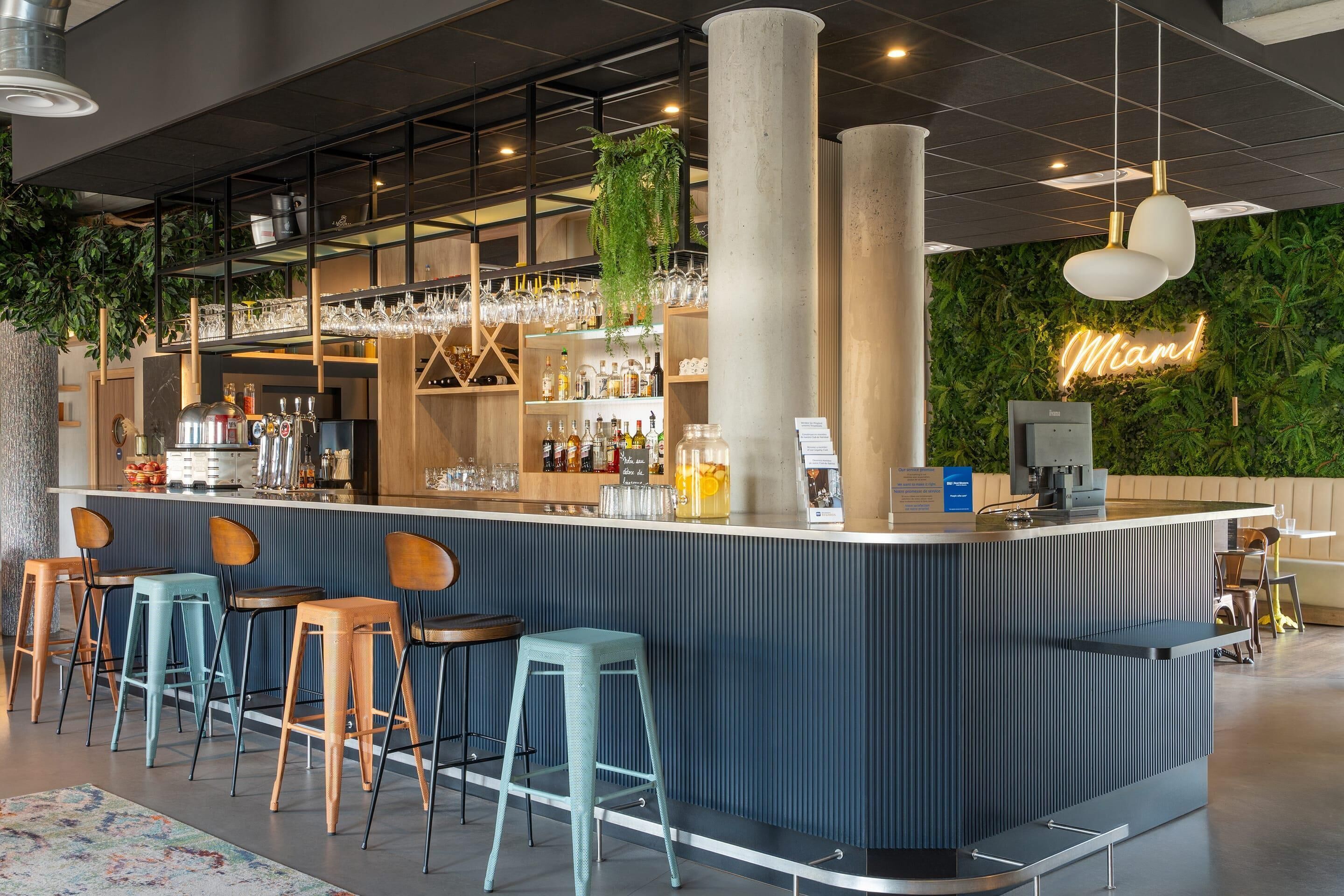 Uma área de bar com bancos, balcão e letreiro de neon.