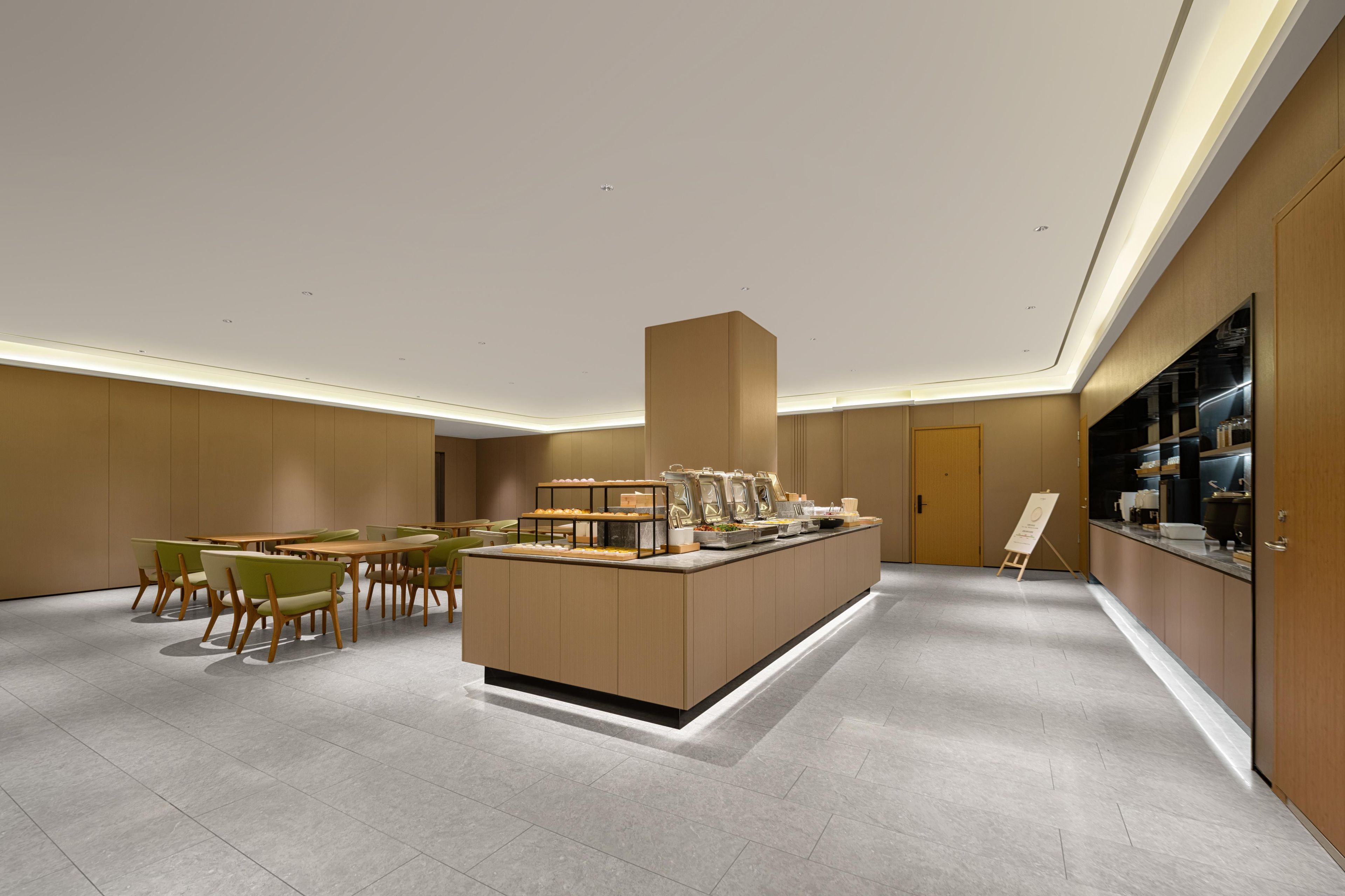 Uma área de refeições moderna com serviço de buffet, mobiliário de madeira e um design limpo e minimalista.