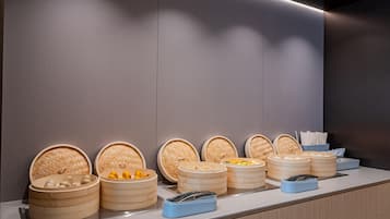 Um balcão de buffet com vários vapores de bambu contendo diferentes tipos de comida.