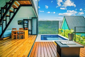 Um deck moderno ao ar livre com piso de madeira, piscina e área de estar com cadeiras.