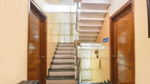 Escada que dá acesso a um andar superior com portas de madeira de ambos os lados.