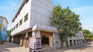 Um edifício com uma placa indicando 'HEMLATA HALL' e 'QUARTOS', anunciando eventos sociais e culturais.