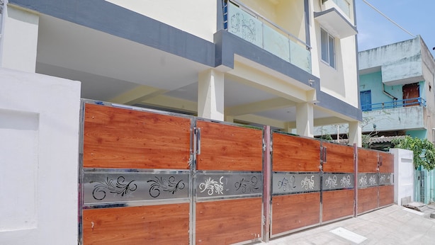 Uma entrada com portão, painéis de metal decorativos e portas de madeira.