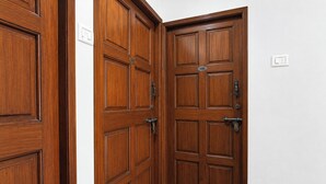 Uma porta dupla de madeira com uma fechadura e maçaneta, e uma placa indicando o quarto 206.