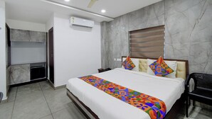 Quarto com cama, ventilador de teto, ar condicionado, guarda-roupa e janela com persianas.