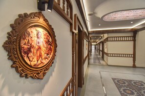 Um corredor com decorações elaboradas nas paredes e um tapete estampado.
