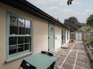 Uma casa com varanda, uma mesa e uma porta.