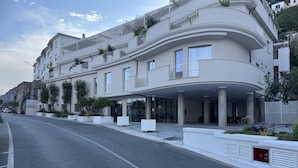Um hotel moderno com fachada curva, janelas amplas e área de entrada coberta.