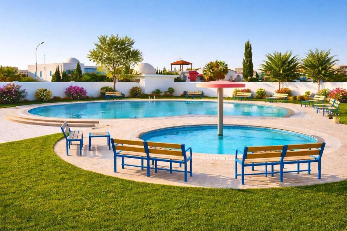 Piscina com bancos e um gazebo.