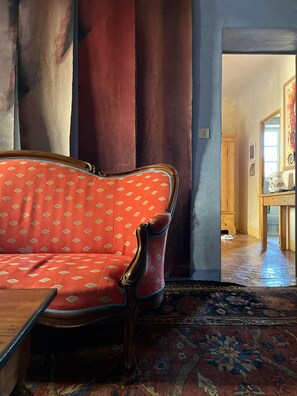 Um quarto com um sofá estampado, uma mesa de madeira e um tapete com padrão.