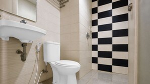 Casa de banho com sanita, lavatório e azulejos xadrez.
