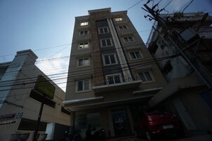 Um edifício de vários andares com fachada plana, diversas janelas e entrada visível.