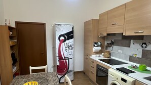 Cozinha compacta com geladeira, micro-ondas, fogão e máquina de lavar.