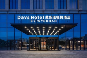 Exterior do Days Hotel by Wyndham, com entrada moderna e sinalização iluminada.