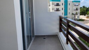 Uma varanda com vista para edifícios, corrimão e uma luminária no teto.
