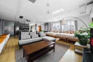 Uma sala de estar moderna com um sofá, uma mesa de centro, uma televisão e uma área de jantar.