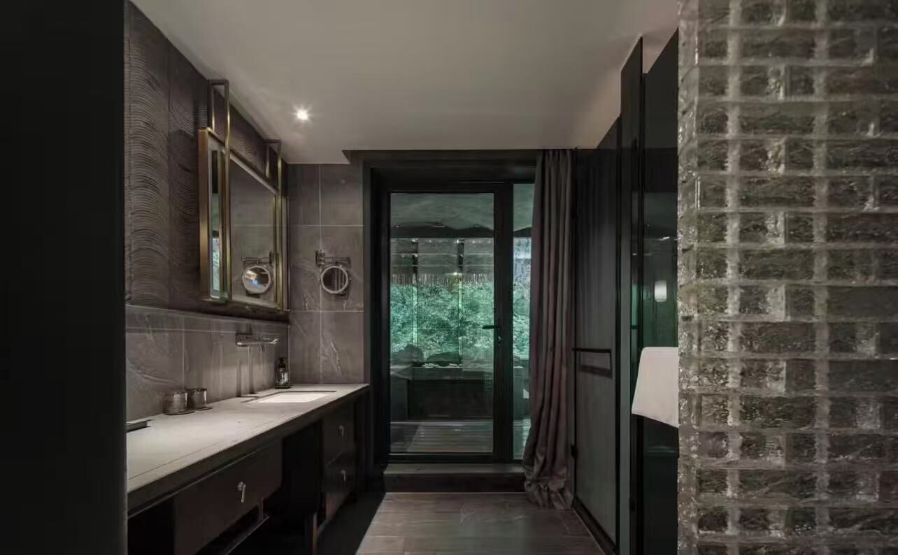 Uma casa de banho moderna com um espelho grande, uma banheira e uma zona de duche.