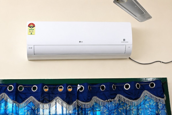 Um ar condicionado fixado na parede, com painel de controle e cabo de alimentação.