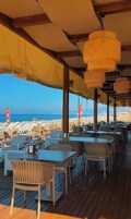 Perto da praia, espreguiçadeiras, guarda-sóis, toalhas de praia 