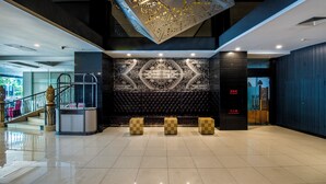Um hall com piso xadrez, escada e teto decorativo.