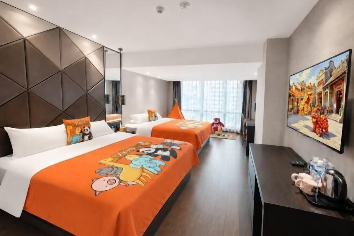 Quarto de hotel com duas camas, uma escrivaninha e uma janela grande.