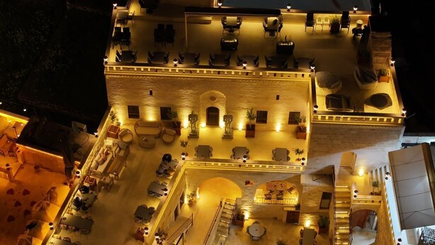 Terraço ao ar livre com vários níveis, áreas de estar e uma escadaria central.