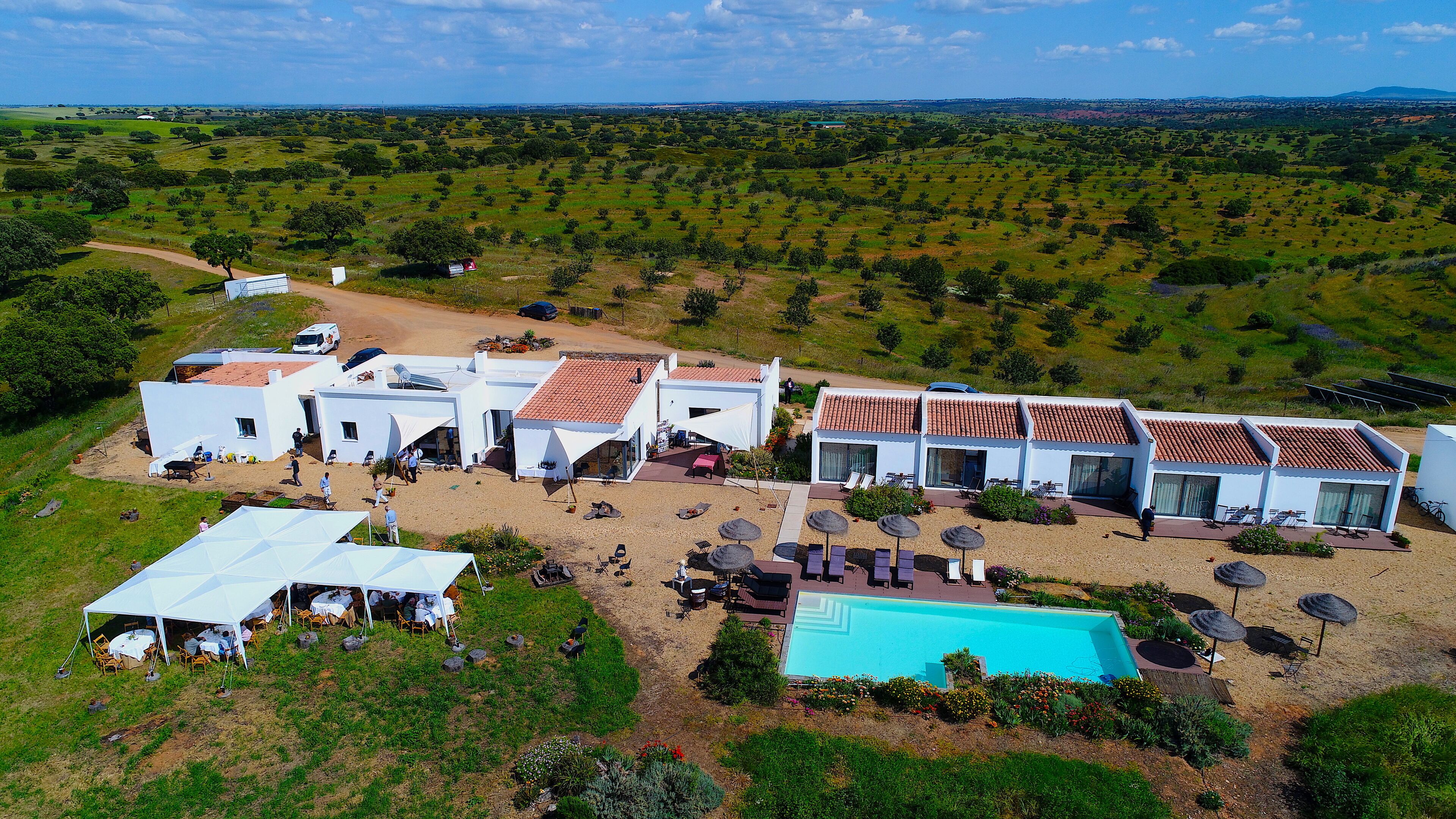 Um resort com vários edifícios, área de estar ao ar livre, piscina e vista para a paisagem circundante.