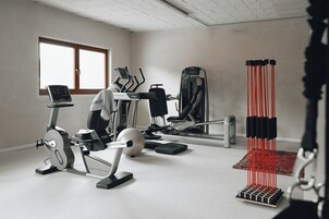 Uma academia com diversos equipamentos de exercício, incluindo esteiras, elípticos e remo.