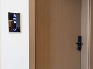 Uma porta de madeira com uma fechadura preta e um mostrador digital na parede à esquerda.