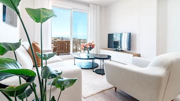 Uma sala de estar moderna com um sofá, uma mesa de centro e uma televisão.