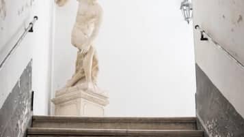 Uma escadaria com uma estátua clássica no topo.