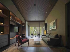 Um interior moderno com sofá, cadeiras, mesa de centro e cozinha.