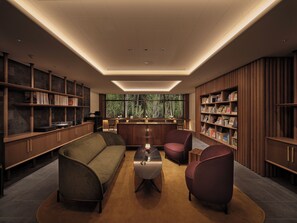 Uma biblioteca moderna com estantes, um sofá, cadeiras e uma mesa de centro.