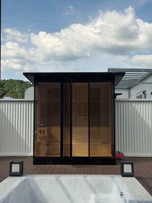 Uma estrutura moderna ao ar livre com porta de vidro, interior em madeira e área de piscina.