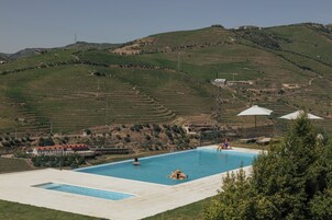 Piscina com vista para vinhedos em socalcos e colinas.