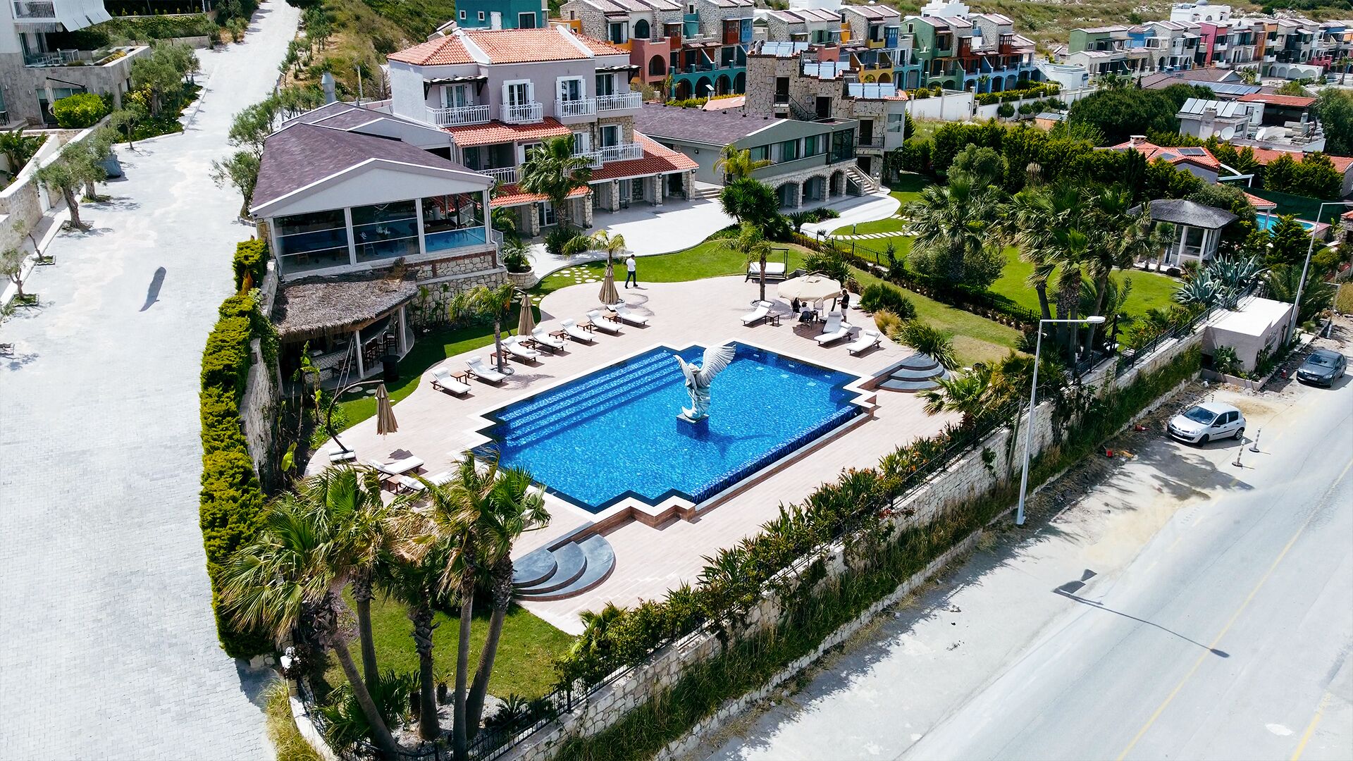Área residencial com piscina, casas e uma rua.