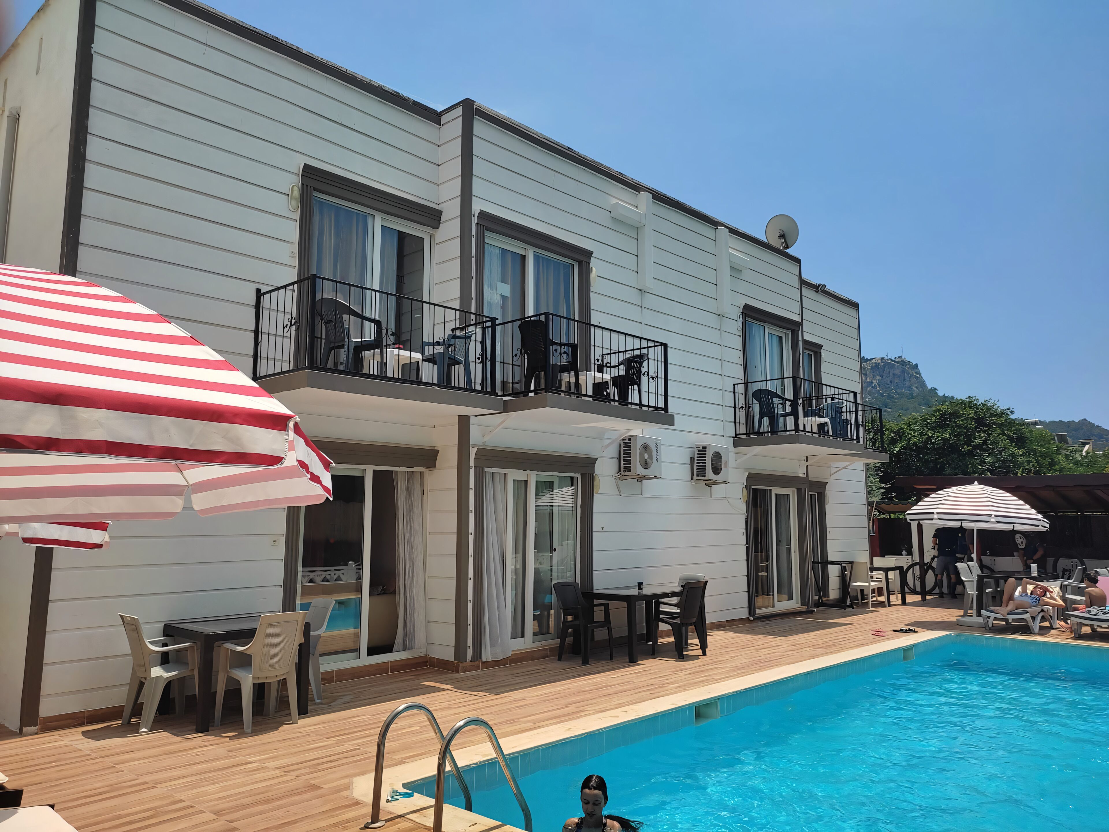 Um hotel com piscina, área de estar externa e varandas.