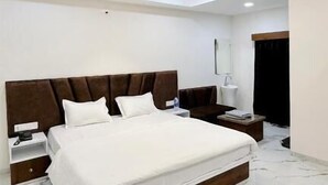 Um quarto moderno com uma cama, mesas de cabeceira, um ventilador de teto e piso de mármore.