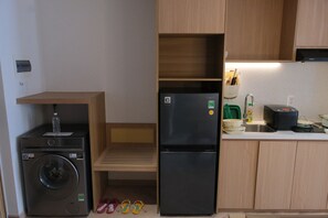 Uma cozinha compacta com máquina de lavar, geladeira e pia.