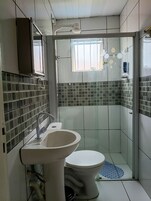 Chuveiro, toalhas de banho, papel higiênico