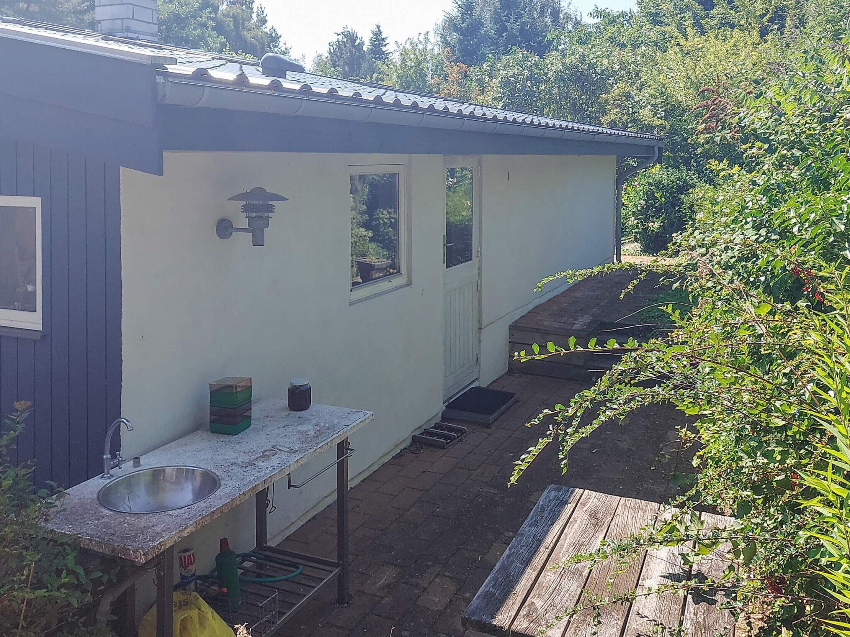 Uma casa com cozinha, incluindo uma pia e uma janela.